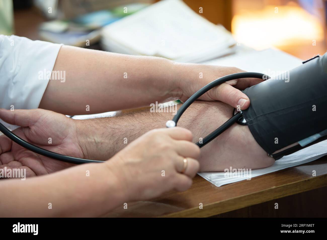A doctor using a sphygmomanometer with a stethoscope revealed arterial ...