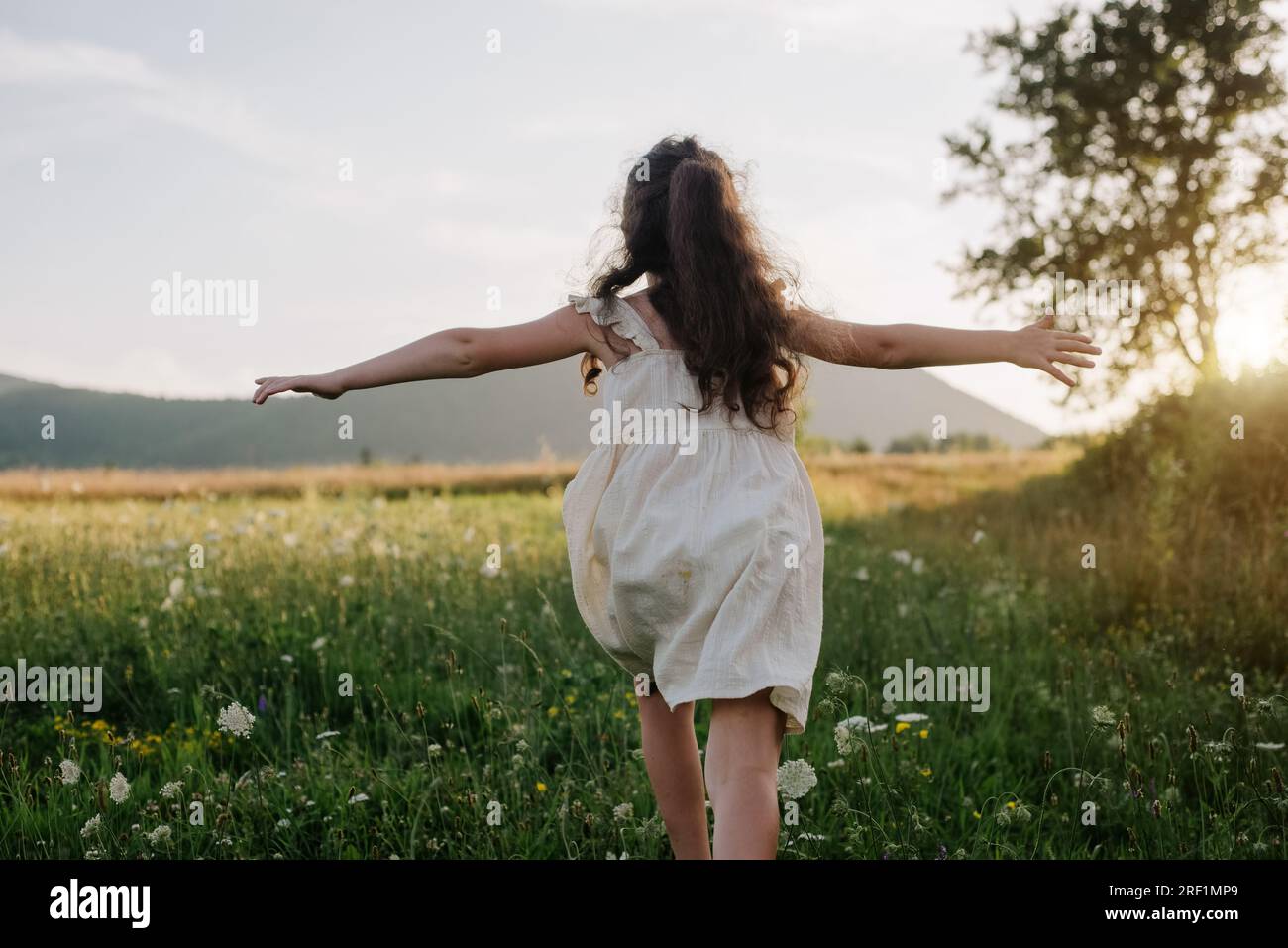 Happy little girl running on background mountains and sky at amazing ...
