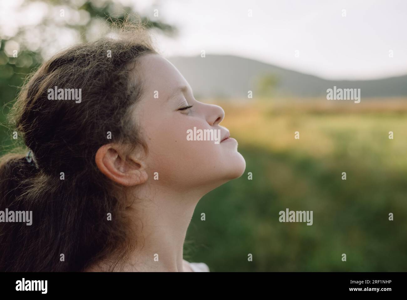 Close up portrait of charming little girl kid enjoy calm nature at warm ...