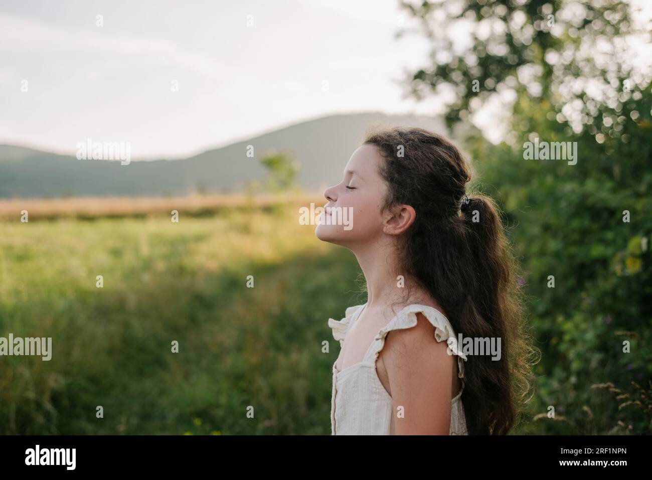 Happy relaxed little child with close eyes in outdoors breathe fresh ...