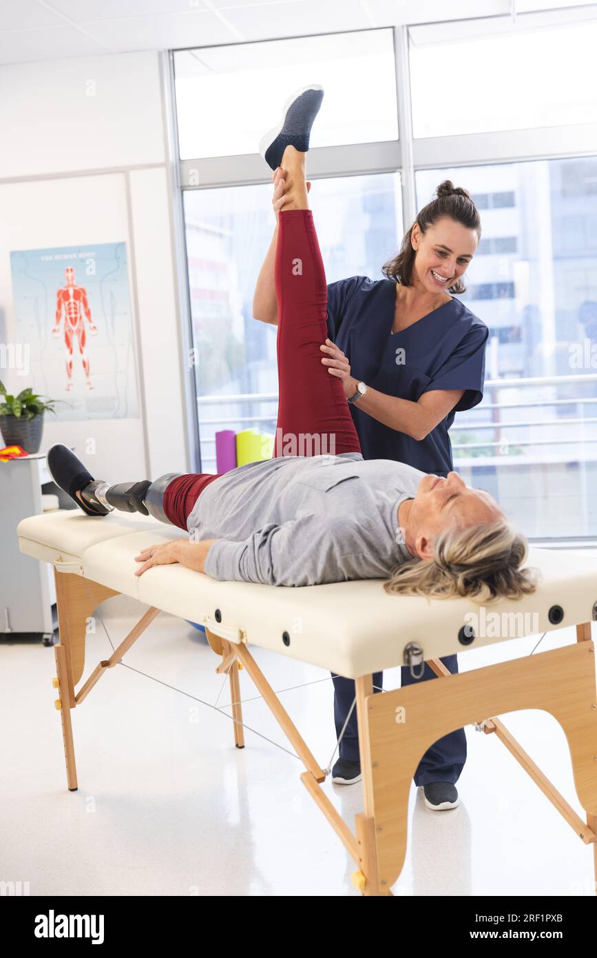 Caucasian female physiotherapist and senior woman with artificial leg ...