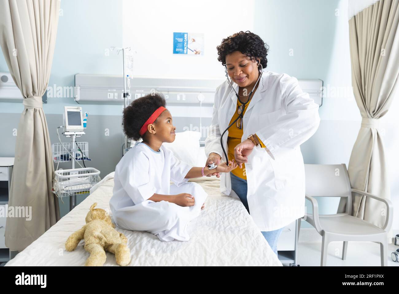 African american female doctor examining girl patient using stethoscope ...