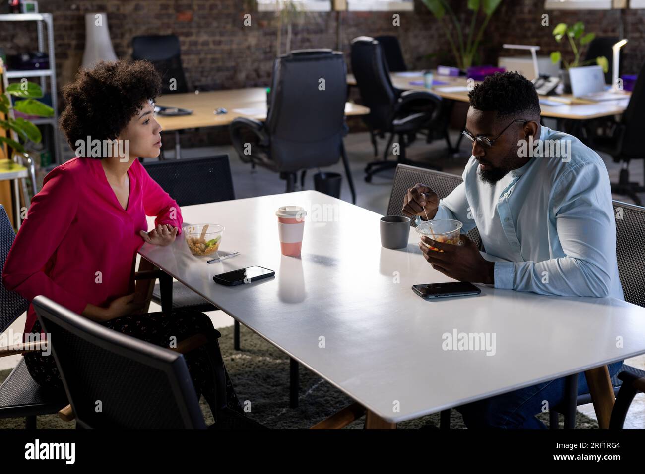 Diverse male and female colleagues eating lunch, having coffee and ...