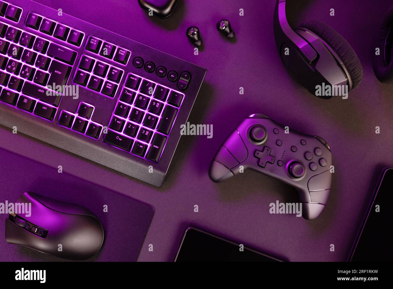 Purple lit keyboard amidst various devices Stock Photo - Alamy