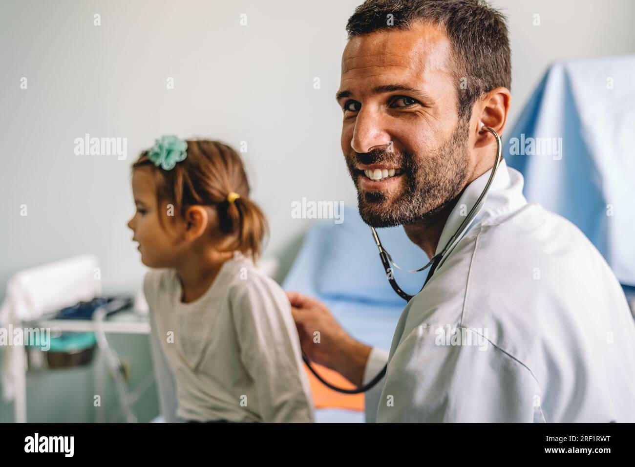 Doctor examines a child with stethoscope in examination room ...