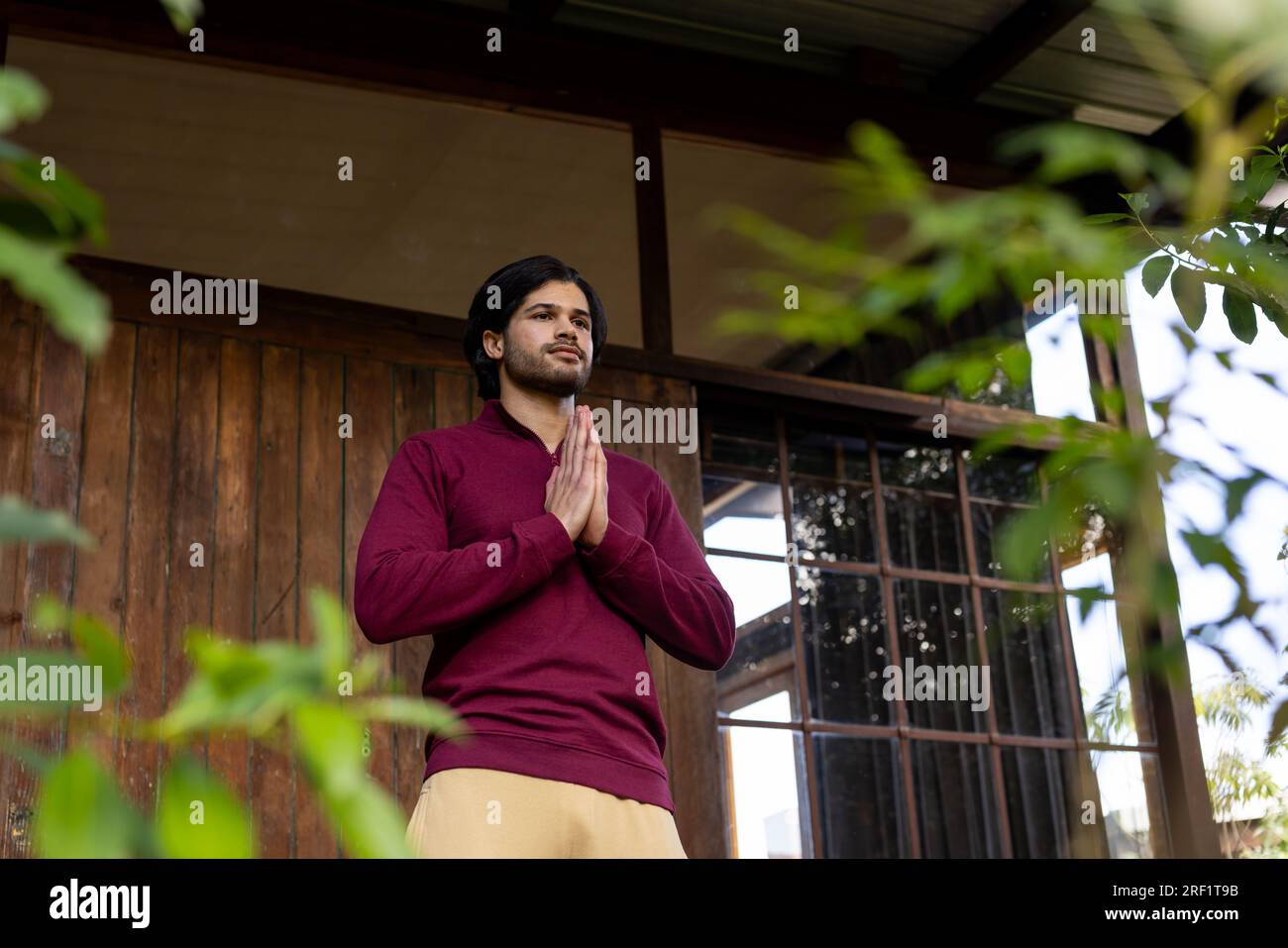 Focused indian man practicing yoga on sunny terrace Stock Photo - Alamy