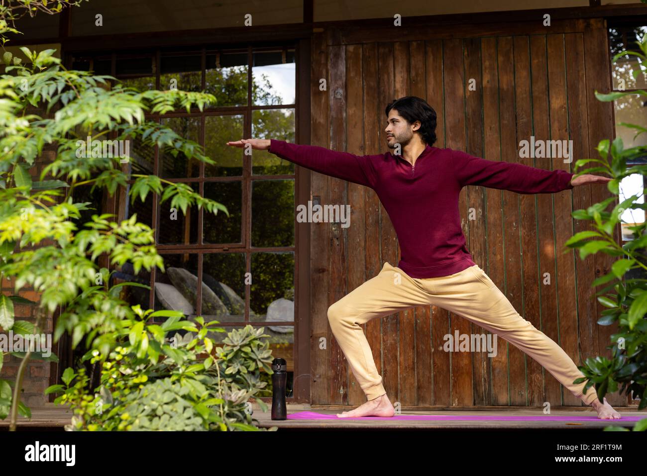 Focused indian man practicing yoga on sunny terrace Stock Photo - Alamy