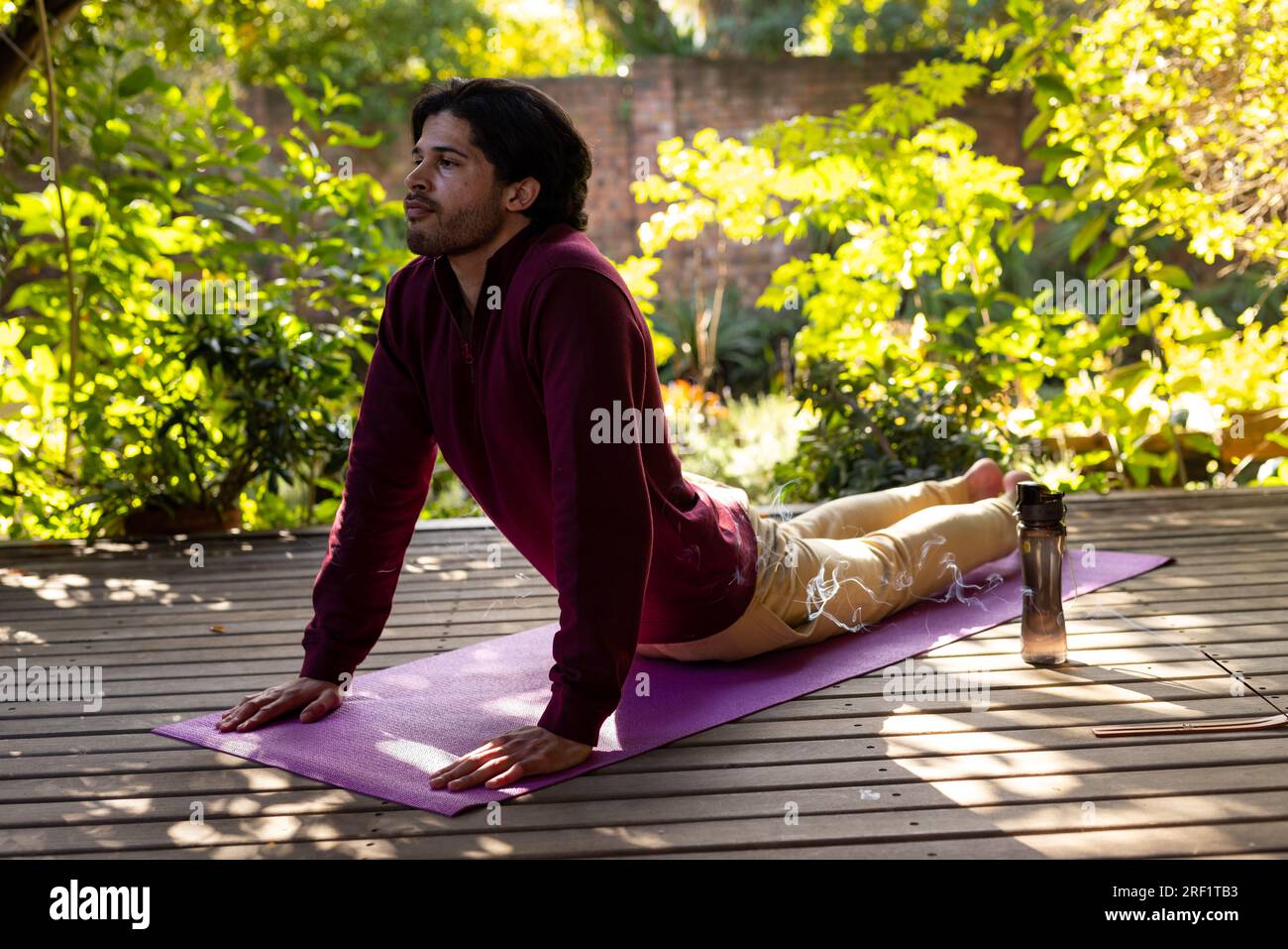 Focused indian man practicing yoga on sunny terrace Stock Photo - Alamy