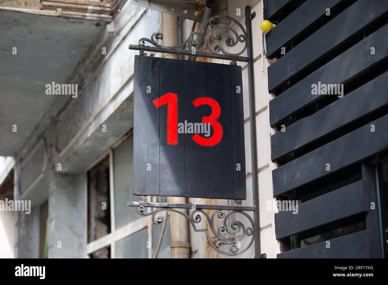 House number thirteen is written in red paint on a black background ...