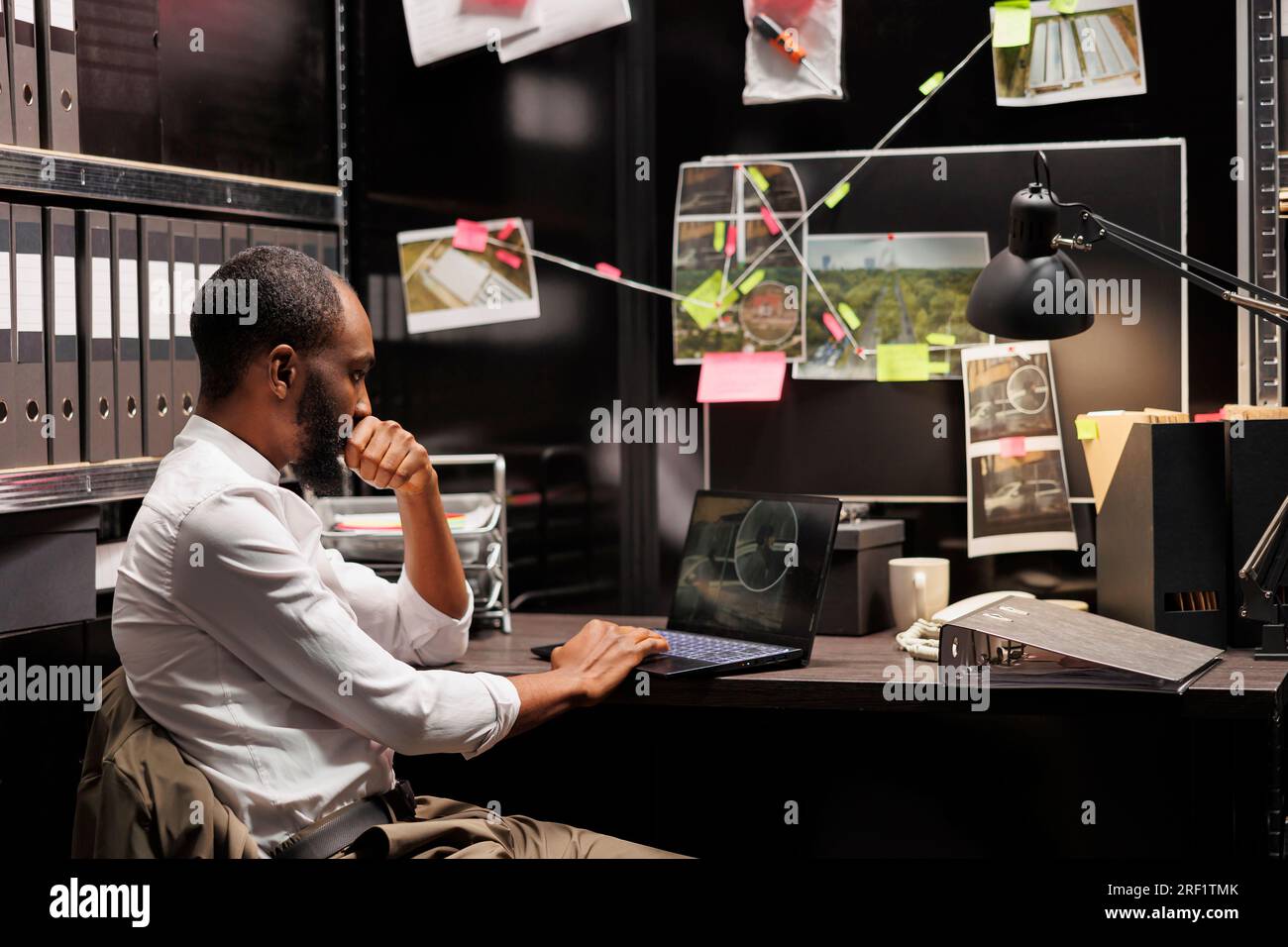 Private detective wathing cctv camera photos on laptop while sitting at ...