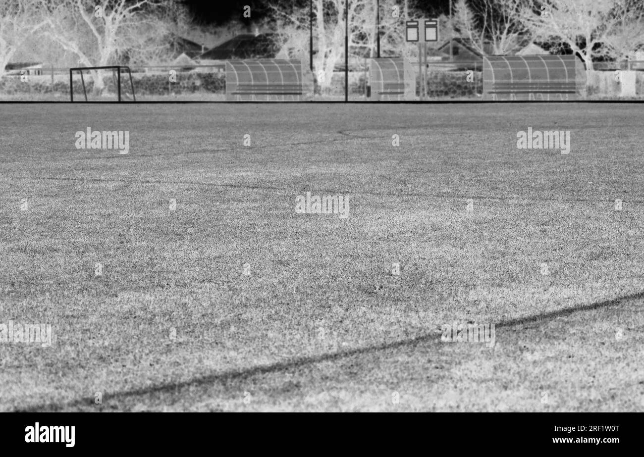 Negative, a view of an empty football field covered with grass with ...