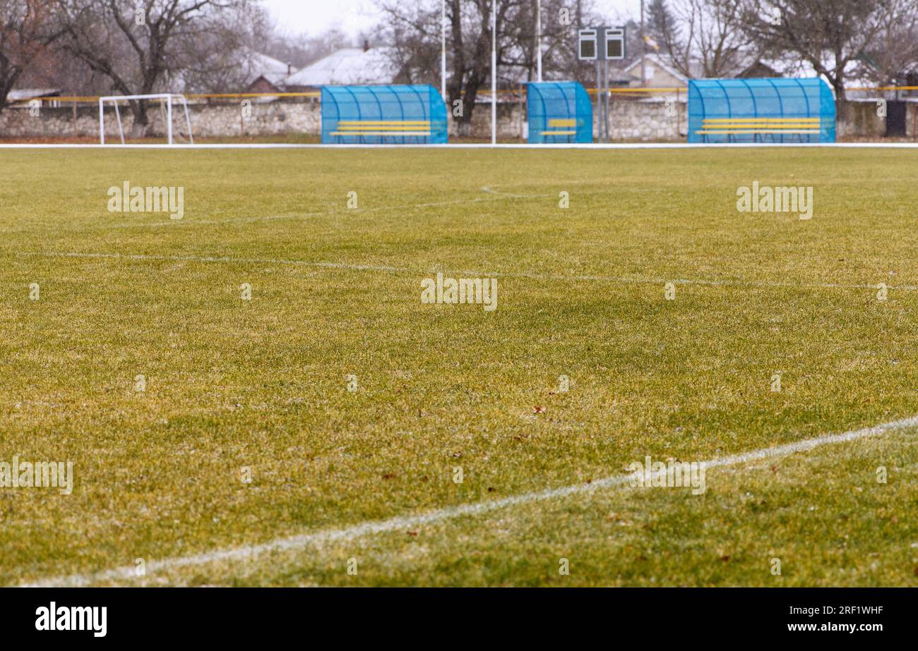 A view of an empty football field covered in grass with gates and ...
