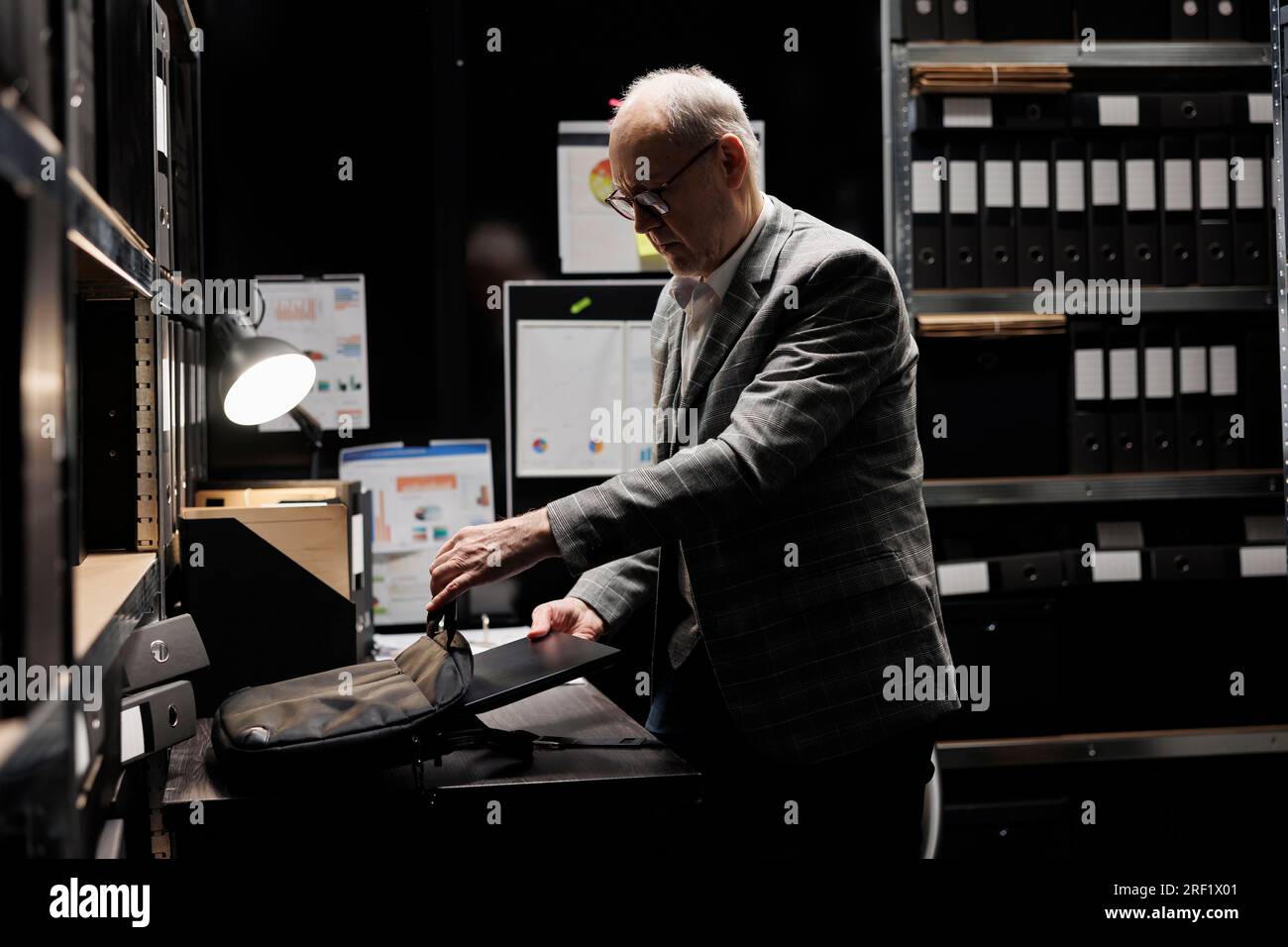 Bureaucratic businessman manager packing laptop up in suitcase bag ...