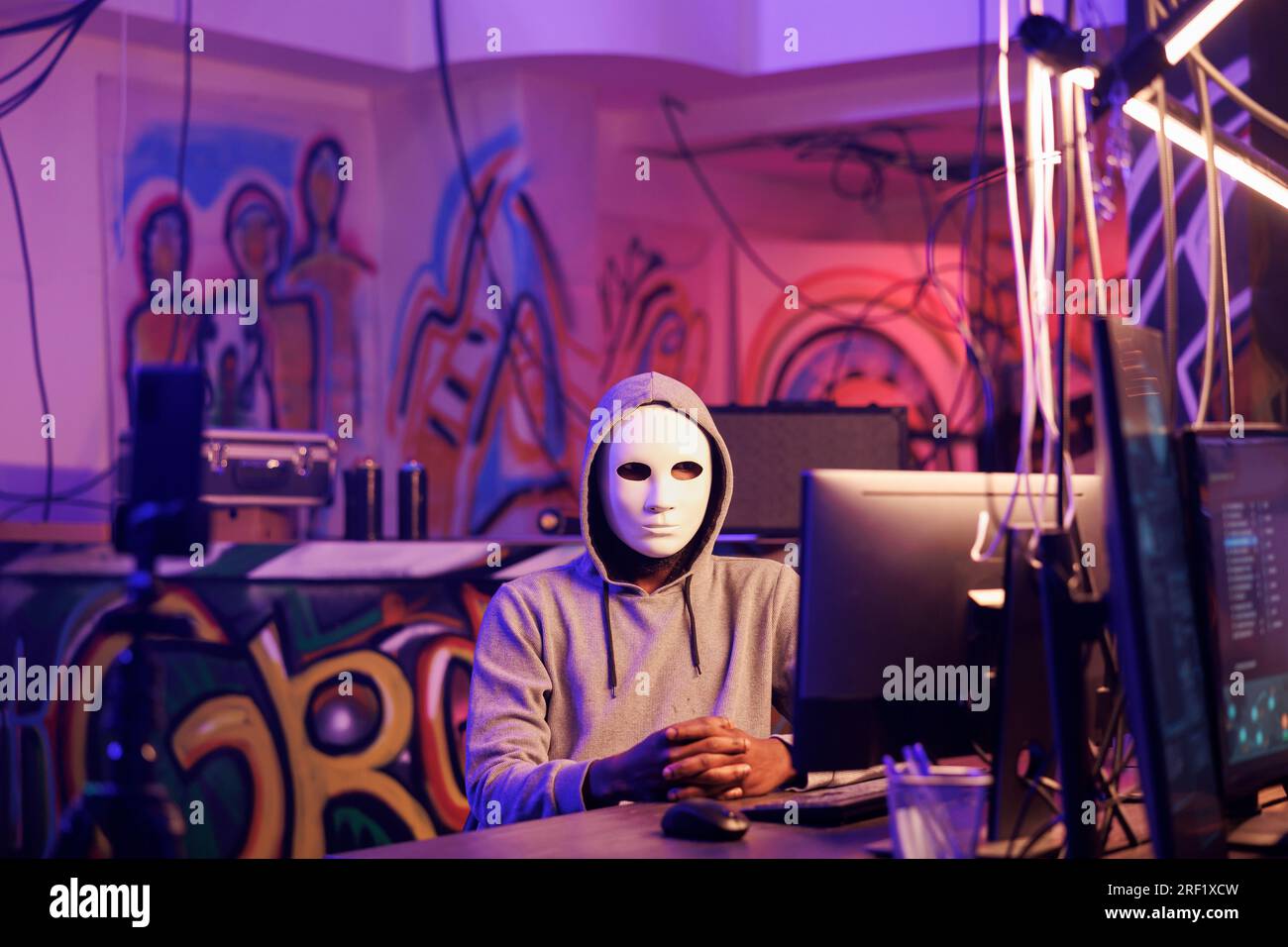 Anonymous hacker streaming threat message while doing illegal ...