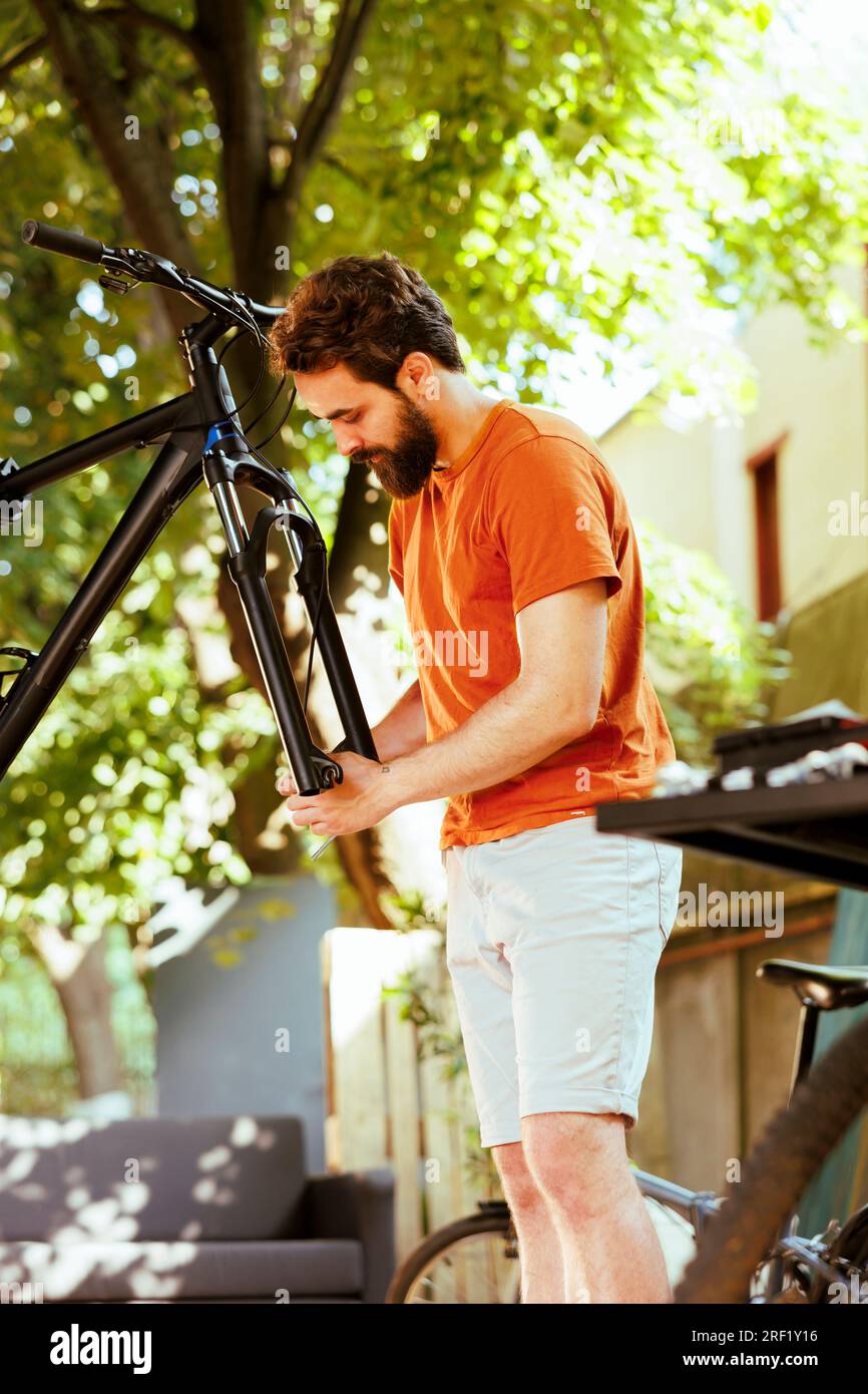 Vibrant young caucasian man adjusting and securing bicycle headset and ...