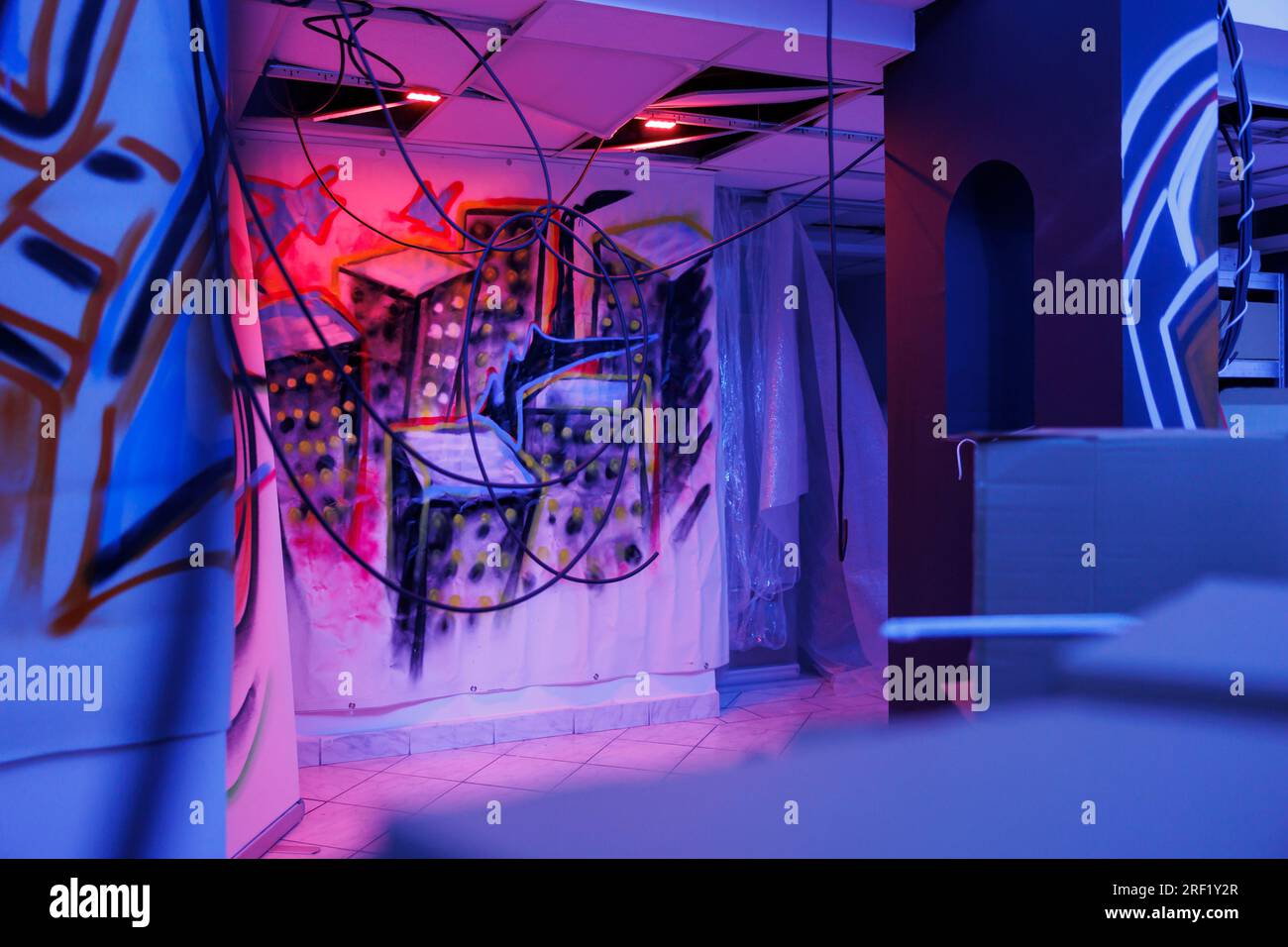 Broken down space with fluorescent glowy lights and debris on walls ...