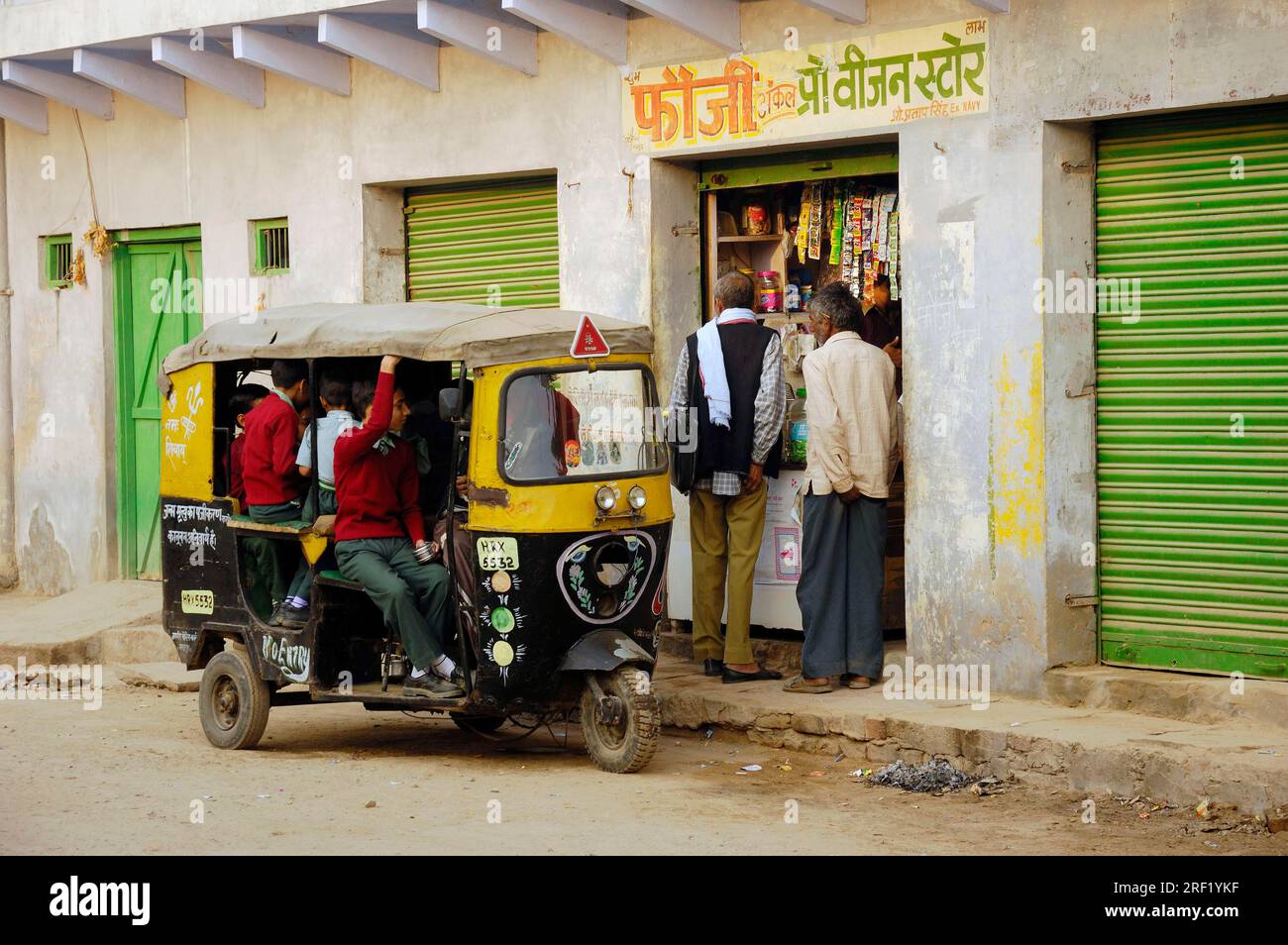 Auto rickshaw with children in front of shop, Bharatpur, Rajasthan ...