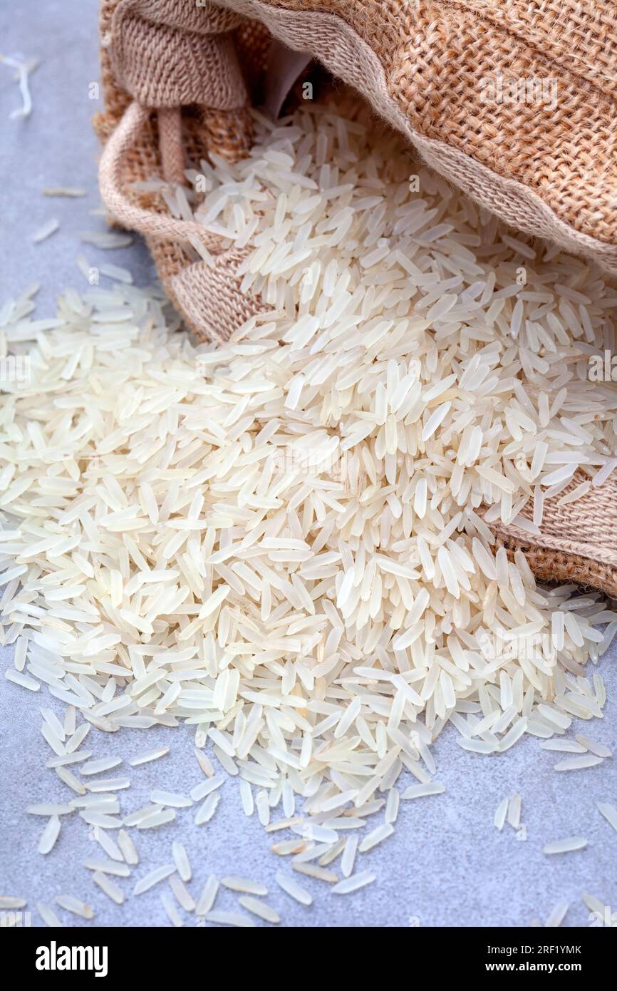 Basmati rice pouring from a burlap sack on grey Stock Photo - Alamy
