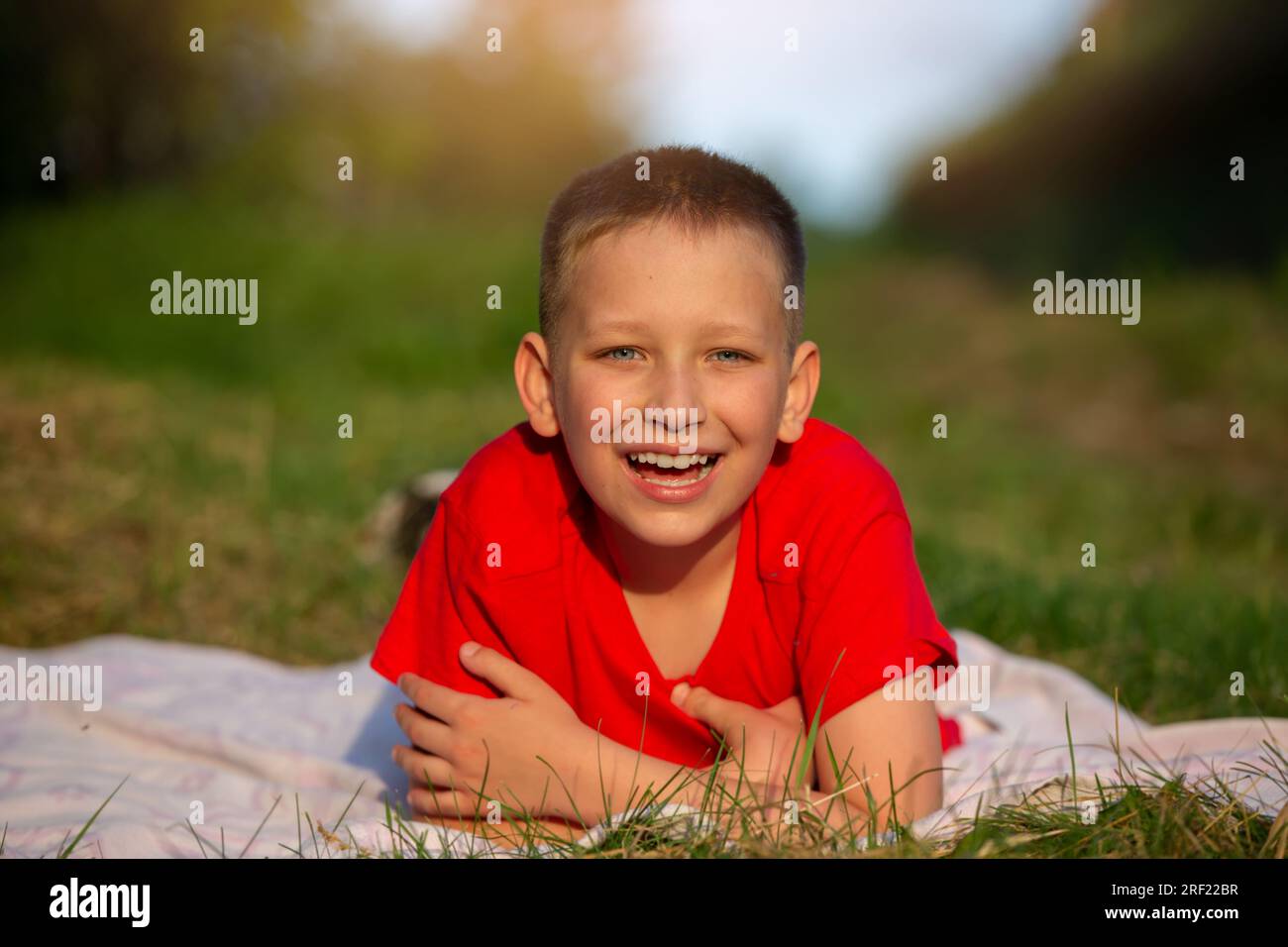 Happy boy lies in grass hi-res stock photography and images - Alamy