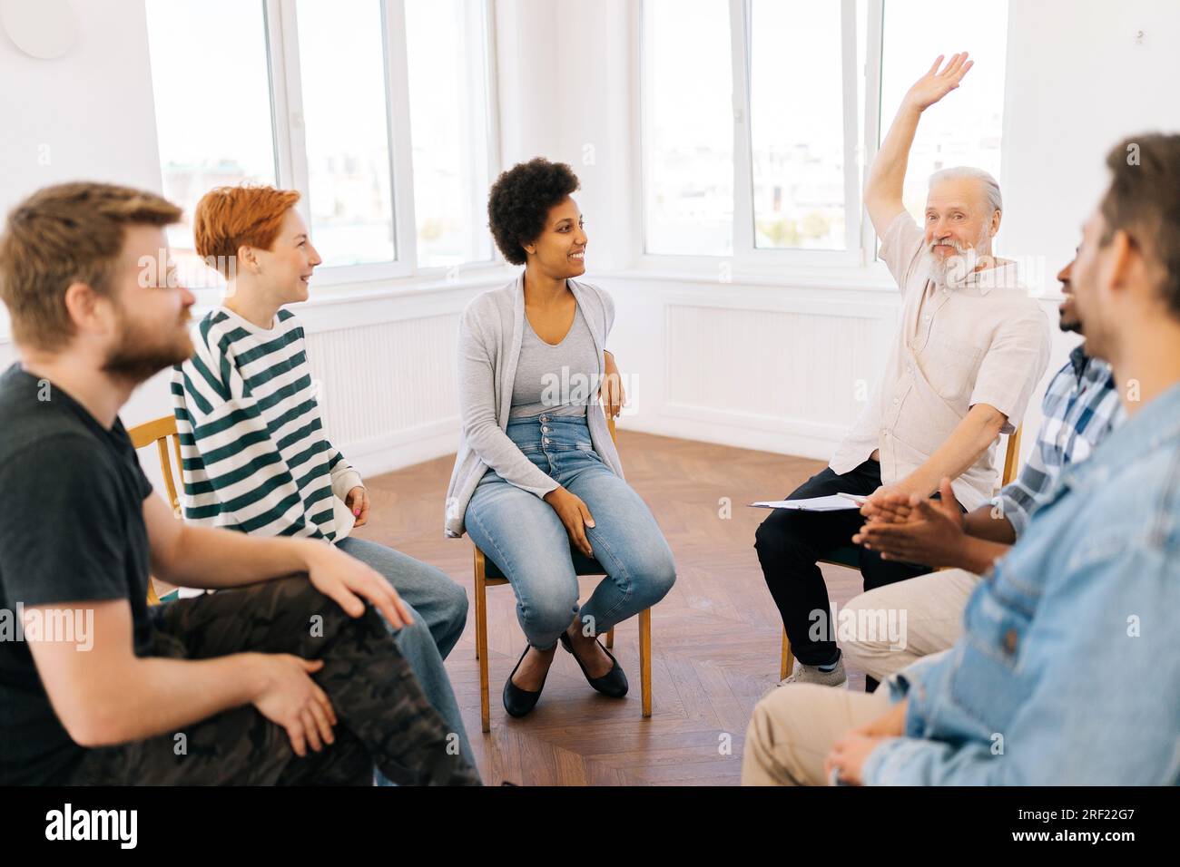 Group of diverse group of people sitting together in circle and raising ...
