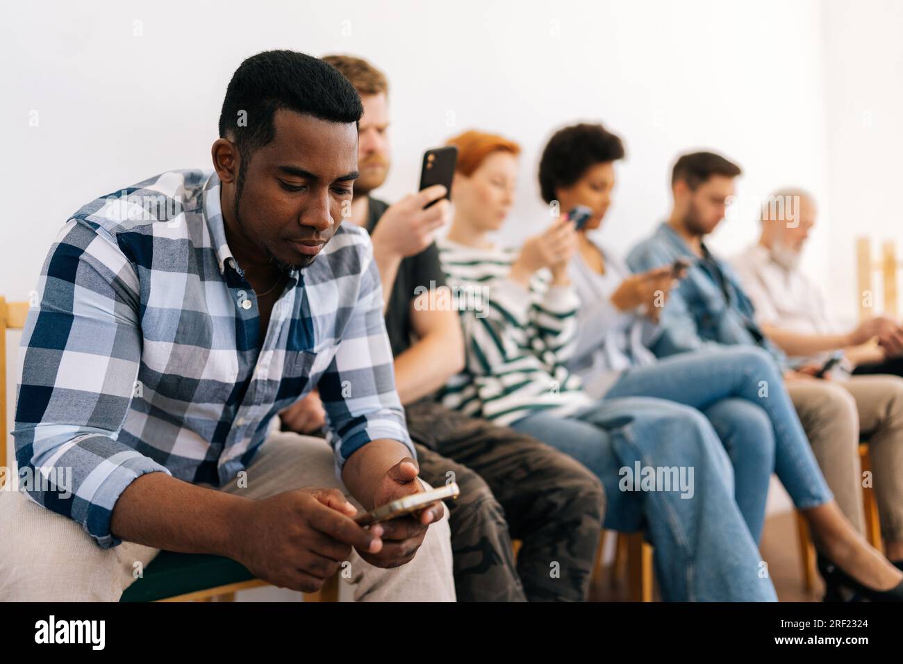 Selective focus of bored multicultural and different ages people in ...