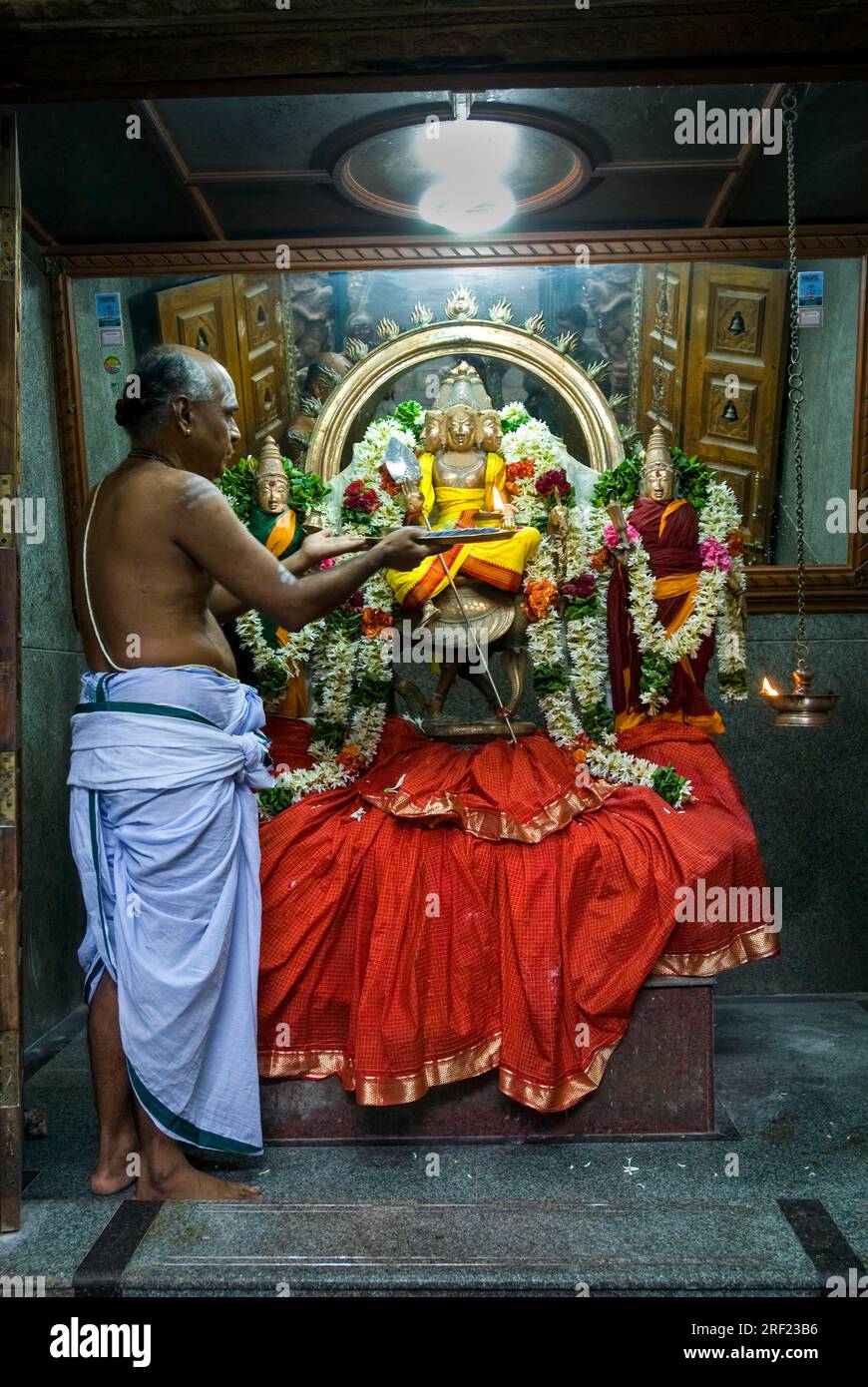 A Priest performing Aarthi, Shanmugar with consorts Valli and Deivanai ...