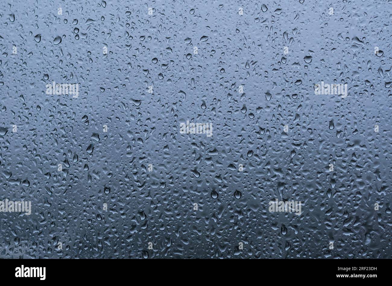 Rain drop on glass window with blue background in monsoon season Stock ...