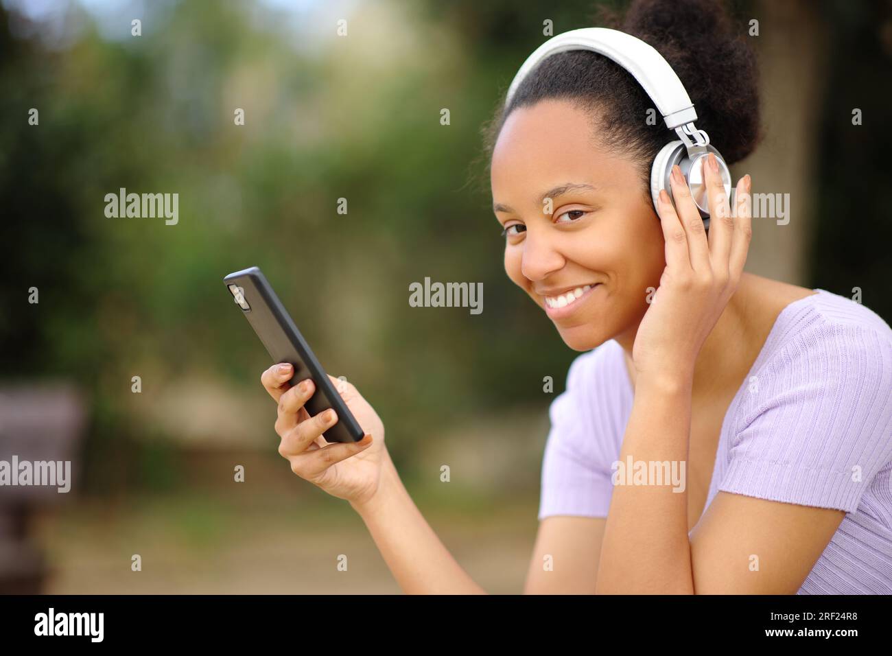 Happy Black Woman Wearing Headphone Listening To Music Looking At
