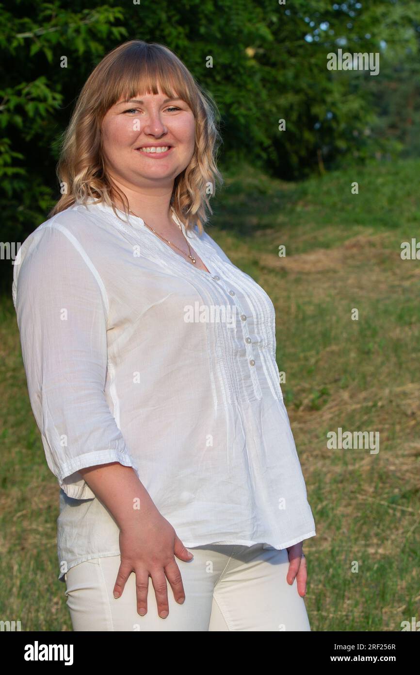 Vertical portrait of a blonde woman of middle age with a large build ...