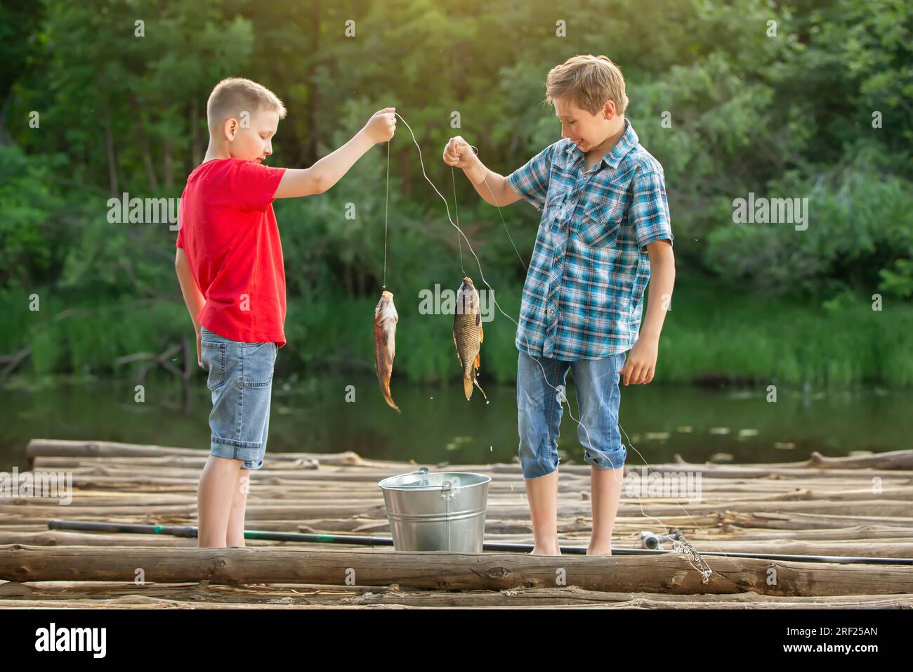 Two boys holding two fish hi-res stock photography and images - Alamy