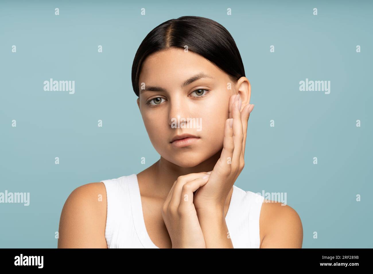 Closeup of glad teenage girl face with natural combed hair touching ...