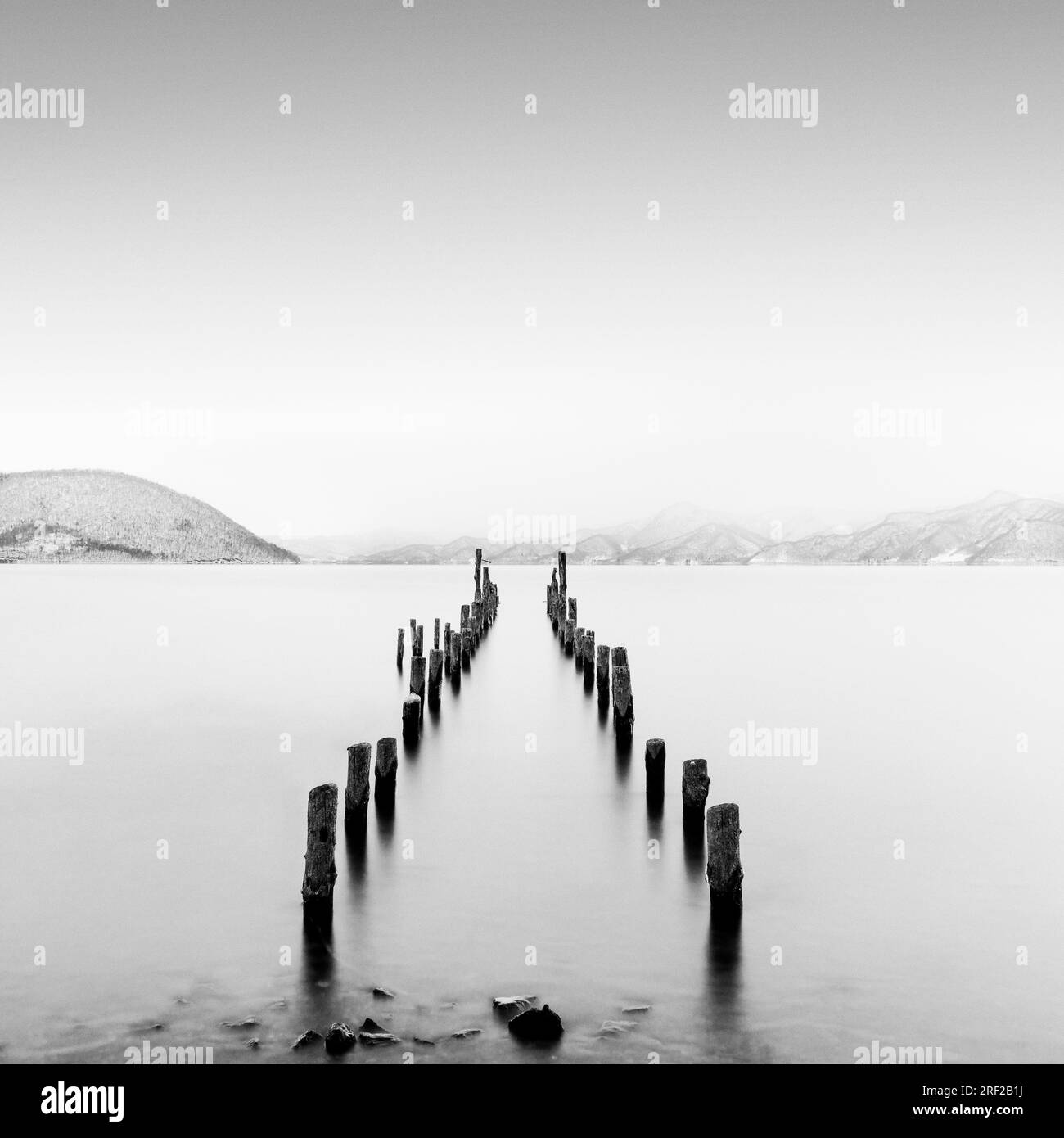 Long exposure shot of wooden sticks in the water at lake Toya, Hokkaido ...