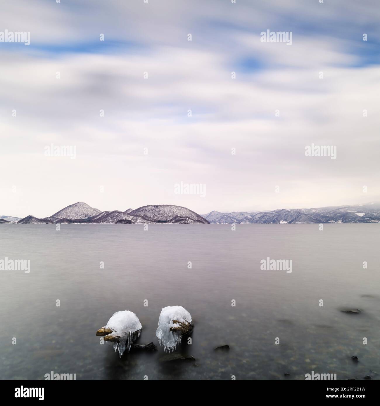 Long exposure shot of logs covered in ice at lake Toya, Hokkaido, Japan ...
