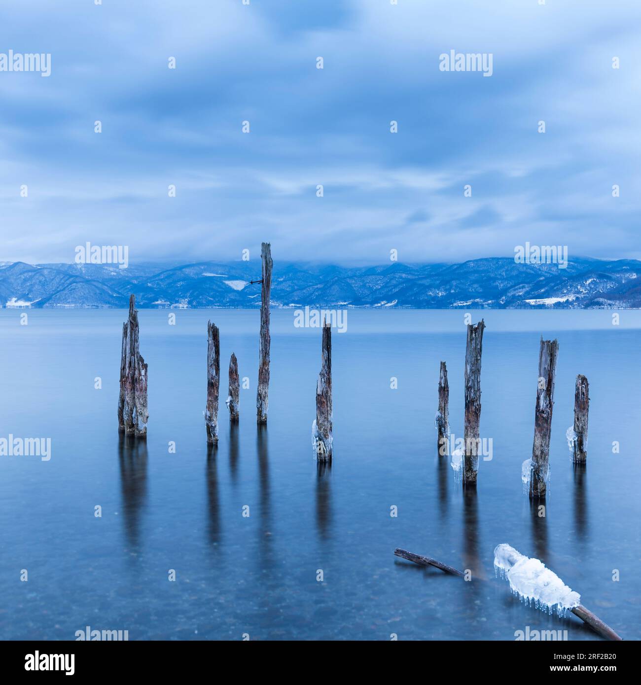 Long exposure shot of wooden sticks in the water at lake Toya, Hokkaido ...