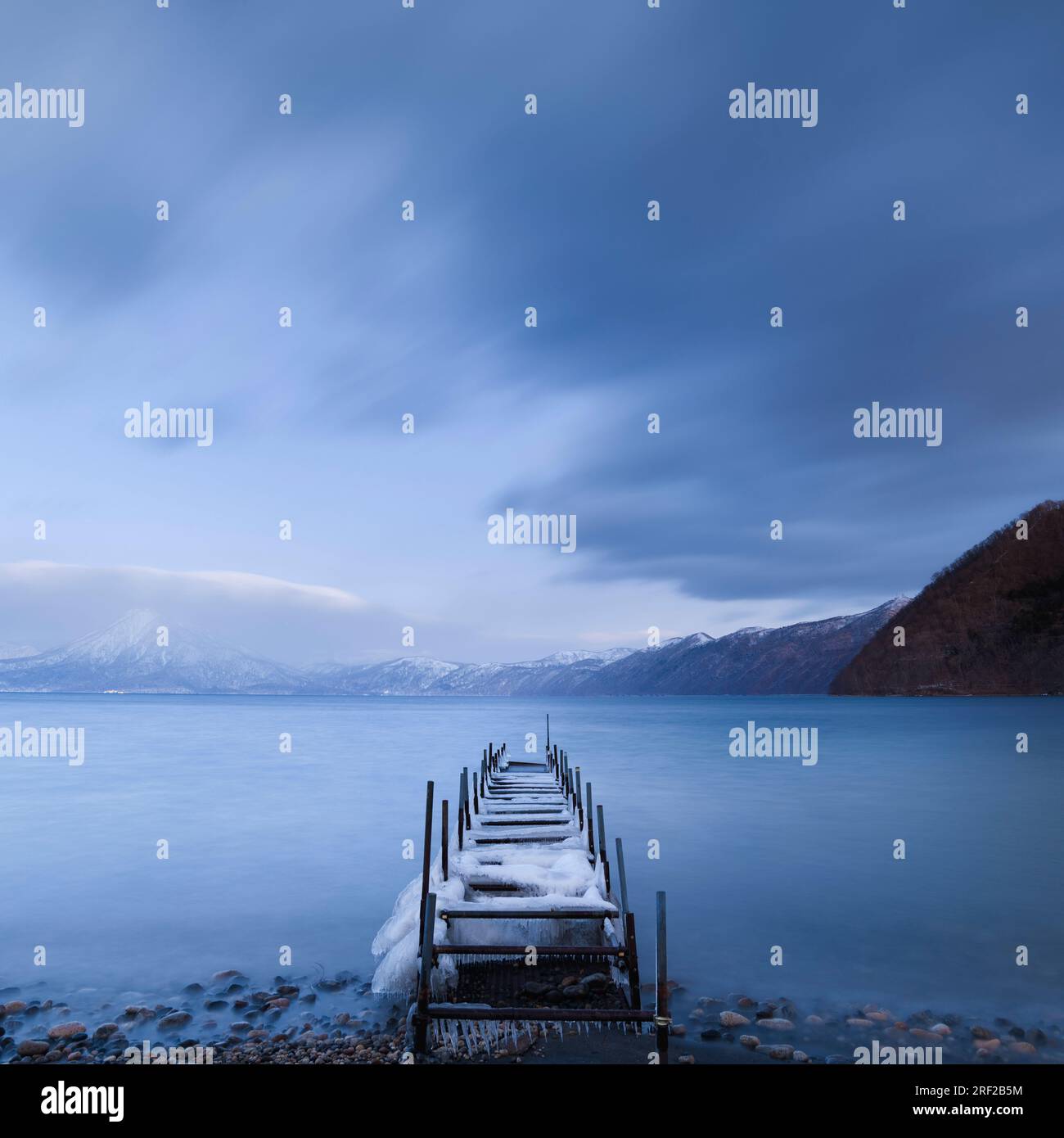 Long exposure shot of boat pier covered in ice at lake Shikotsu ...