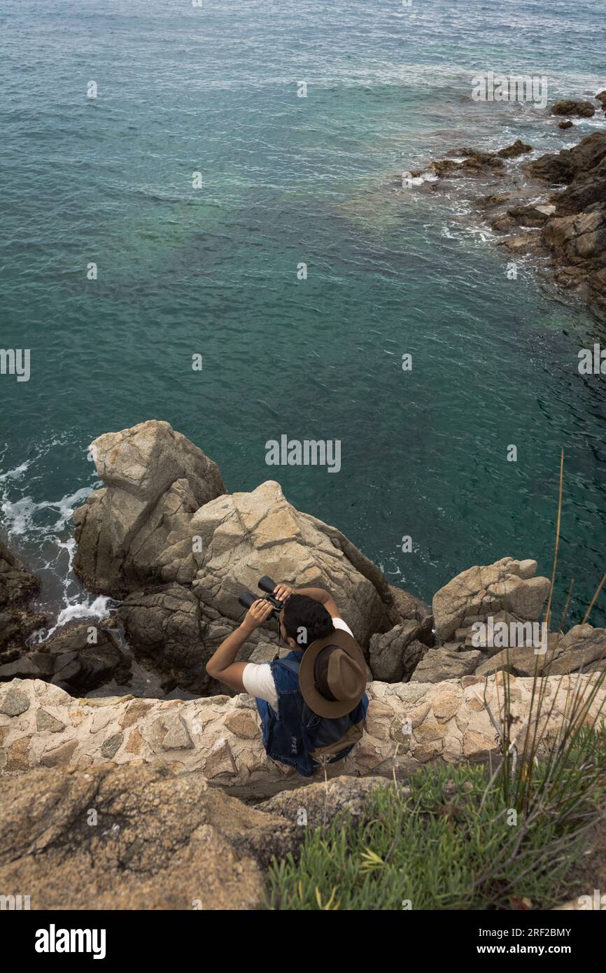 Adventurous man with photo camera and binoculars exploring a roc Stock ...
