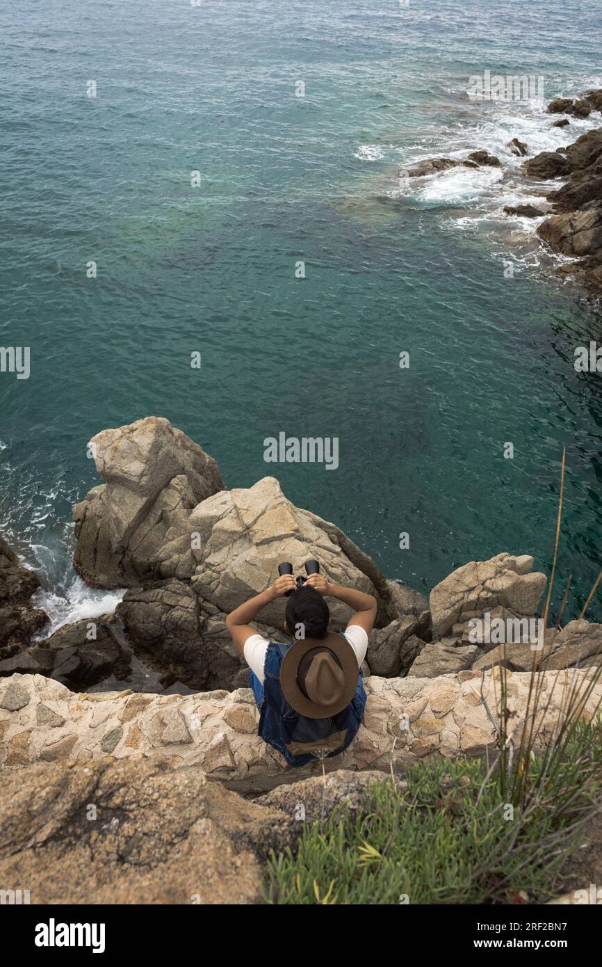 Adventurous man with photo camera and binoculars exploring a roc Stock ...
