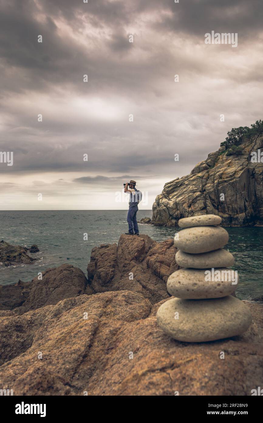 Adventurous man with photo camera and binoculars exploring a roc Stock ...