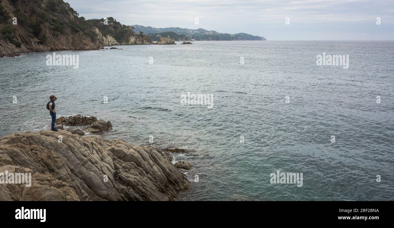 Adventurous man with photo camera and binoculars exploring a roc Stock ...