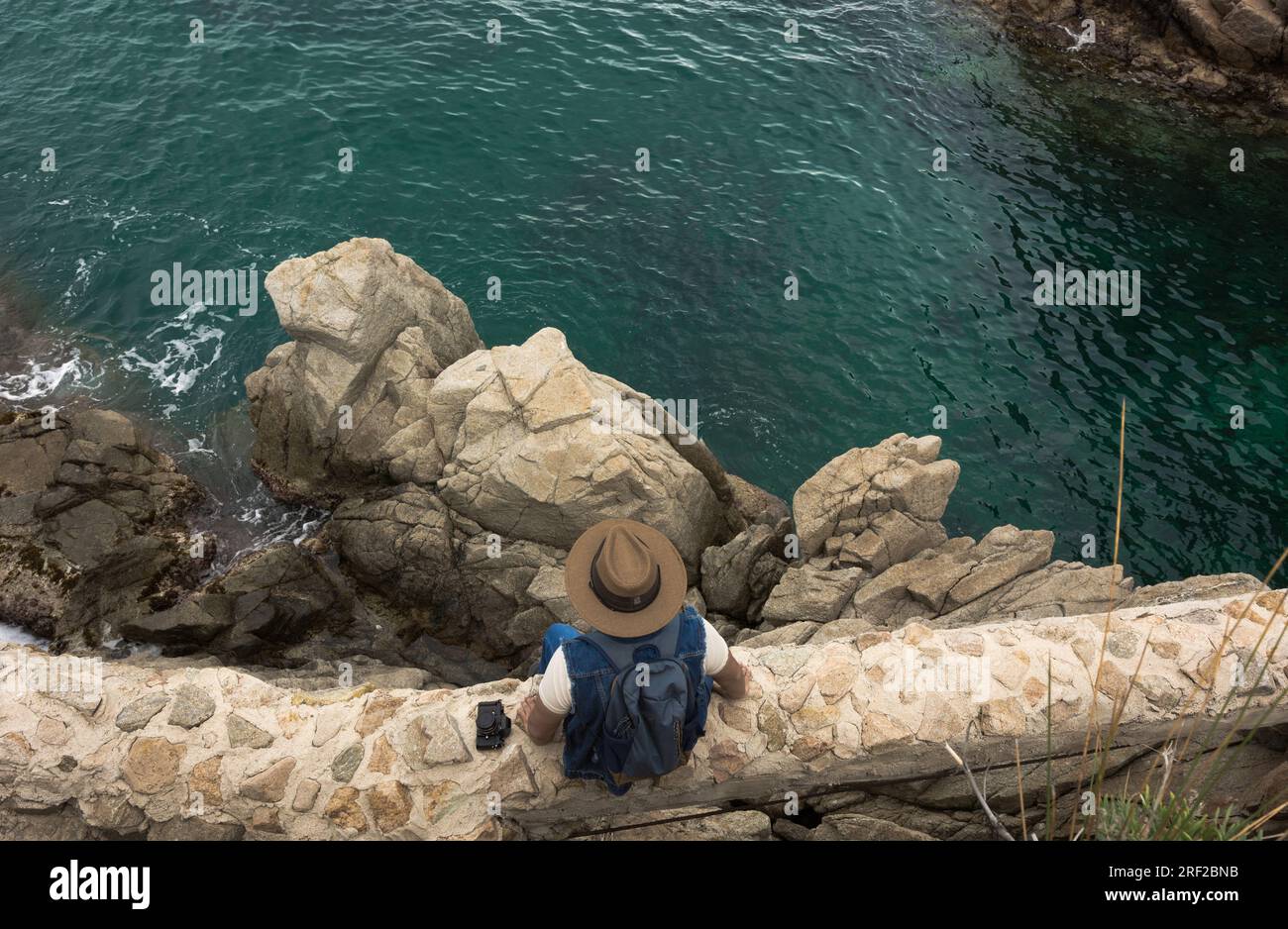 Adventurous man with photo camera and binoculars exploring a roc Stock ...