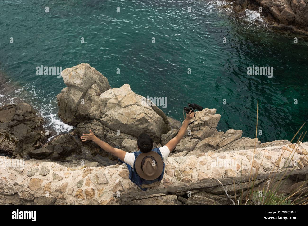 Adventurous man with photo camera and binoculars exploring a roc Stock ...