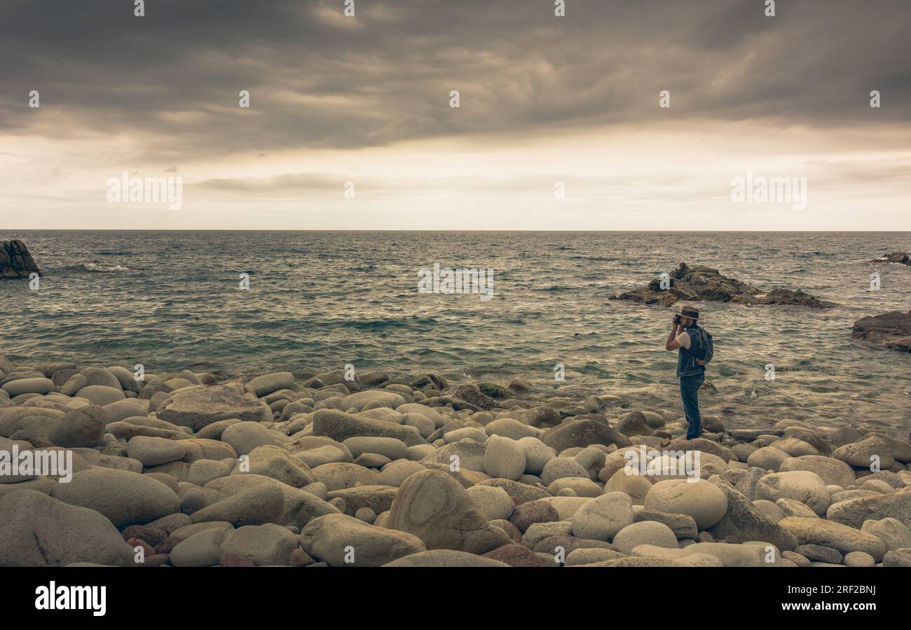 Adventurous man with photo camera and binoculars exploring a roc Stock ...