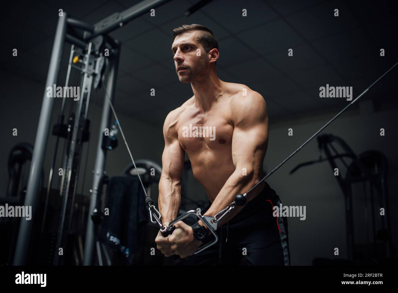 Young man doing chest exercise with cross machine-Edit Stock Photo - Alamy