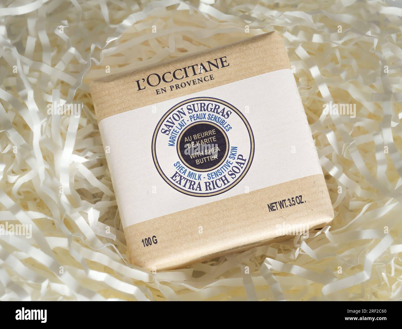 White L'occitane Soap against brightly lit crumbled strips of paper ...