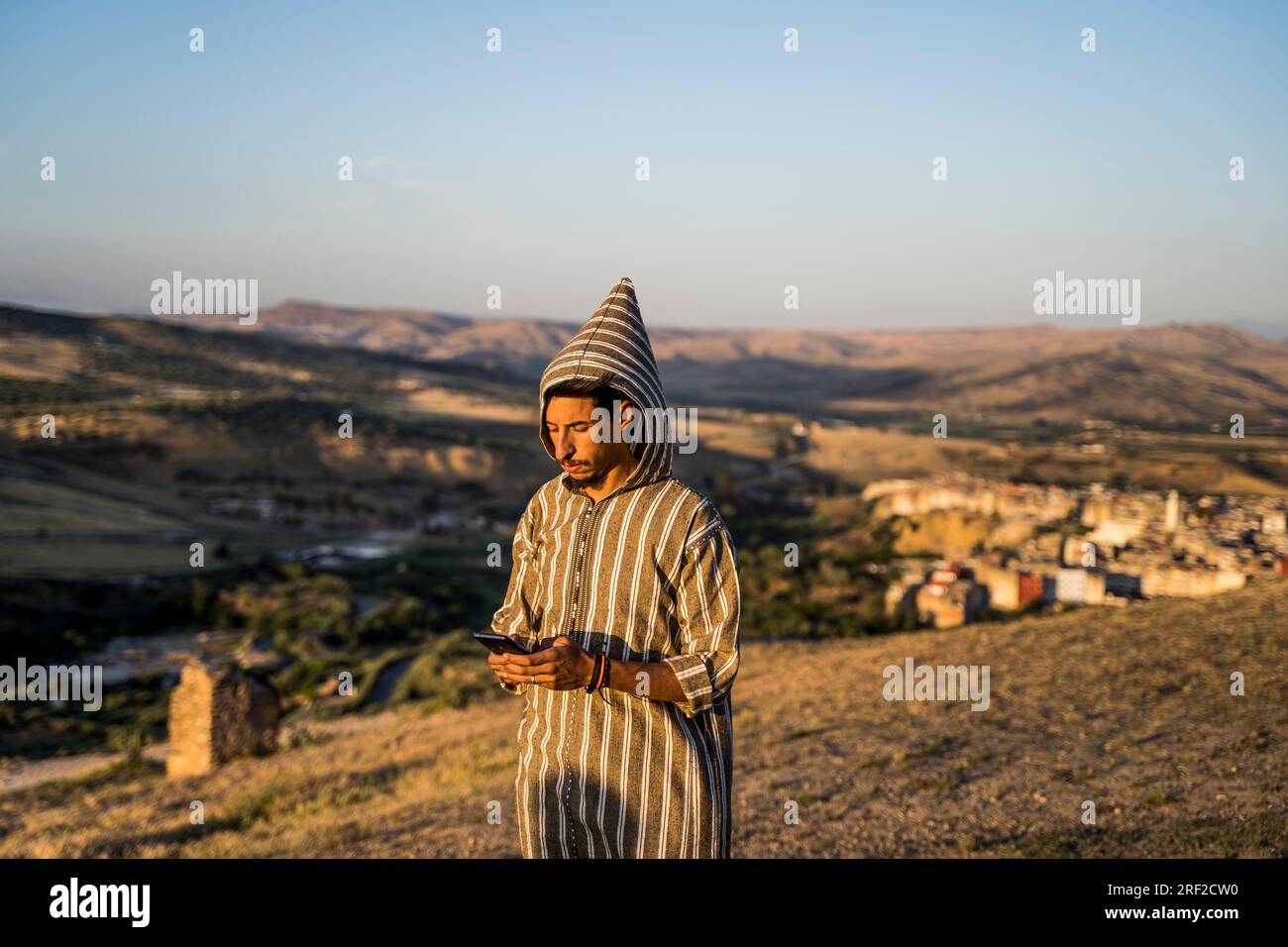Moroccan man in typical Arabic attire with mobile phone in hand Stock ...