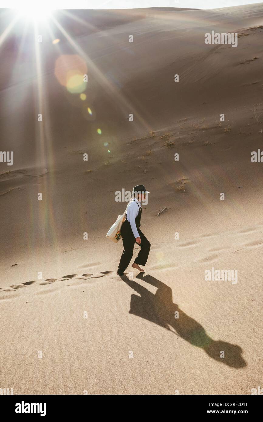 female hiker walks alone with her shadow in great sand dunes park Stock ...