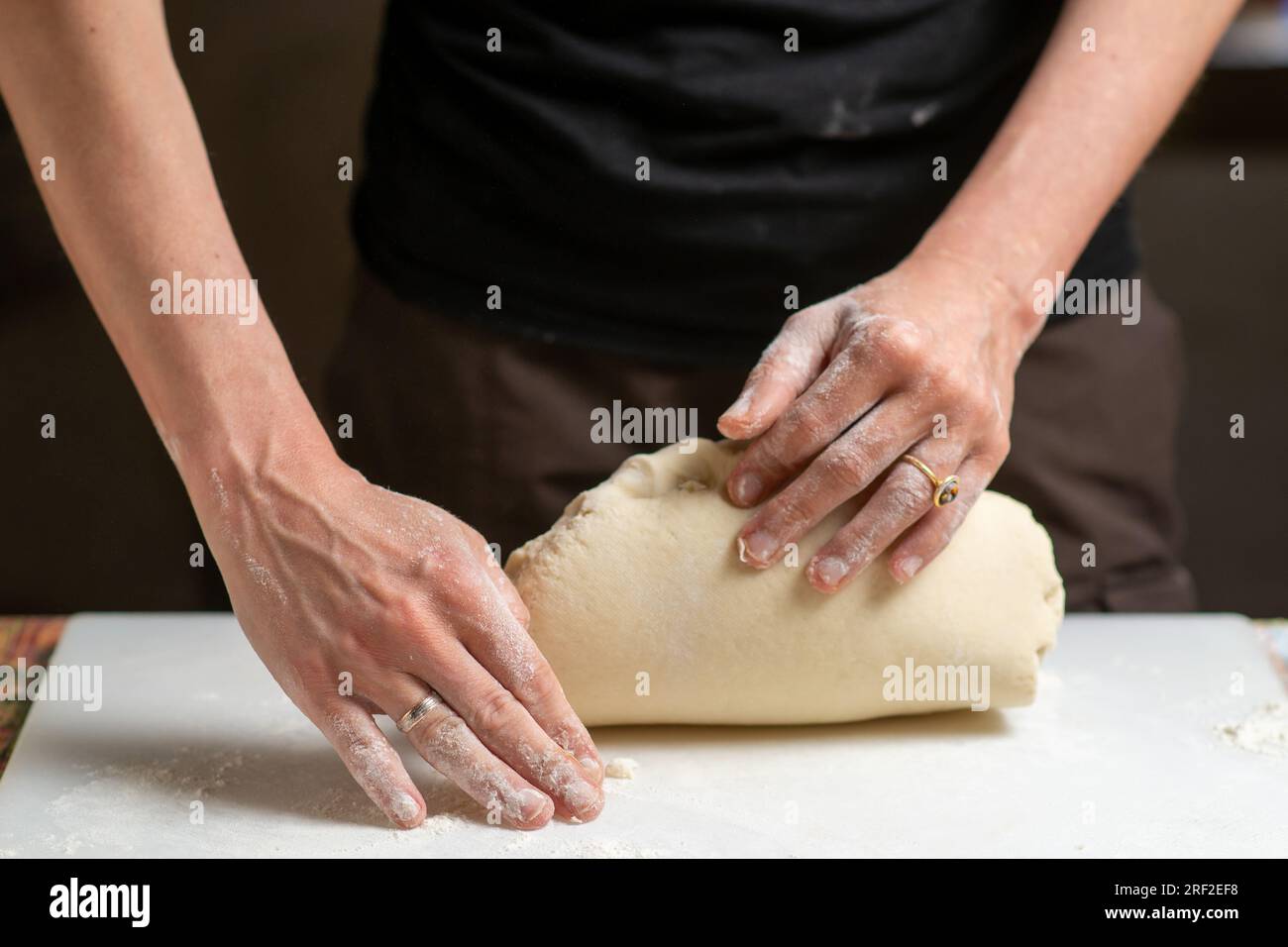 Cooking dough. Women's hands kneading dough in kitchen. Unrecognizable ...