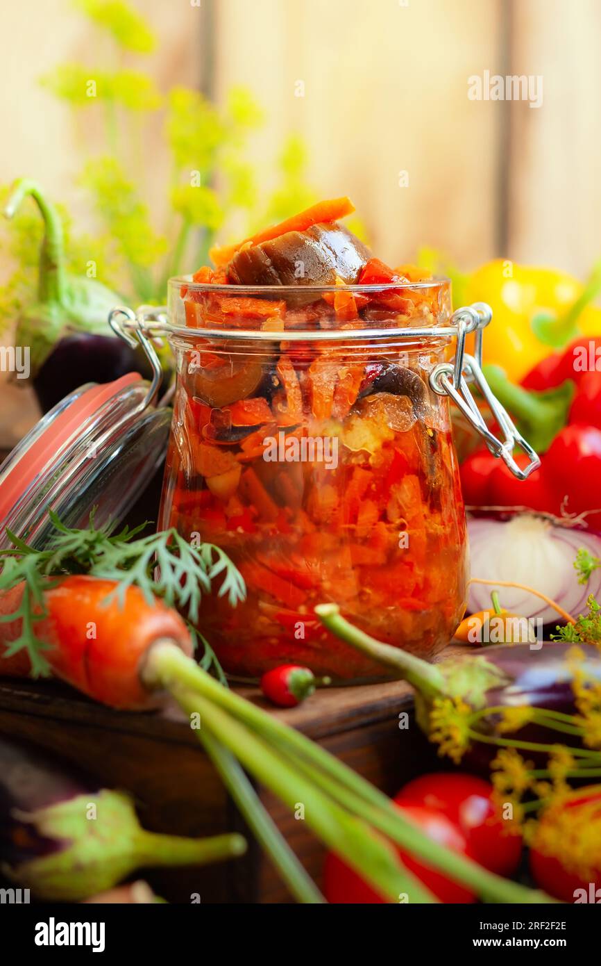 Homemade preserved from eggplant with vegetables in glass jar ...