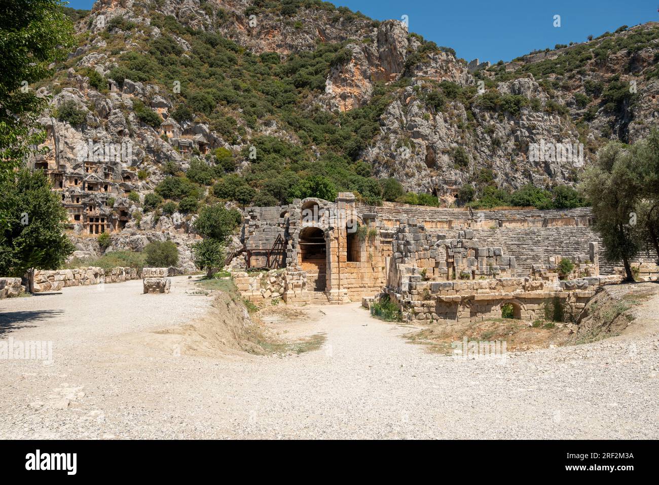 The ruins of the amphitheater and ancient rock tombs in the ancient city of Myra in Demre ...