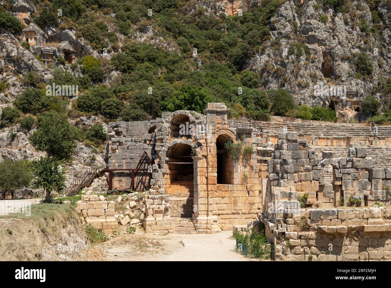 The ruins of the amphitheater and ancient rock tombs in the ancient city of Myra in Demre ...